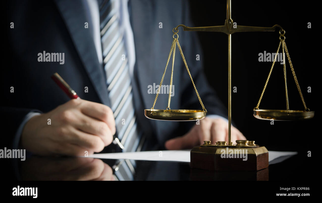 Lawyer or attorney works in his office. Scales on the desk Stock Photo ...