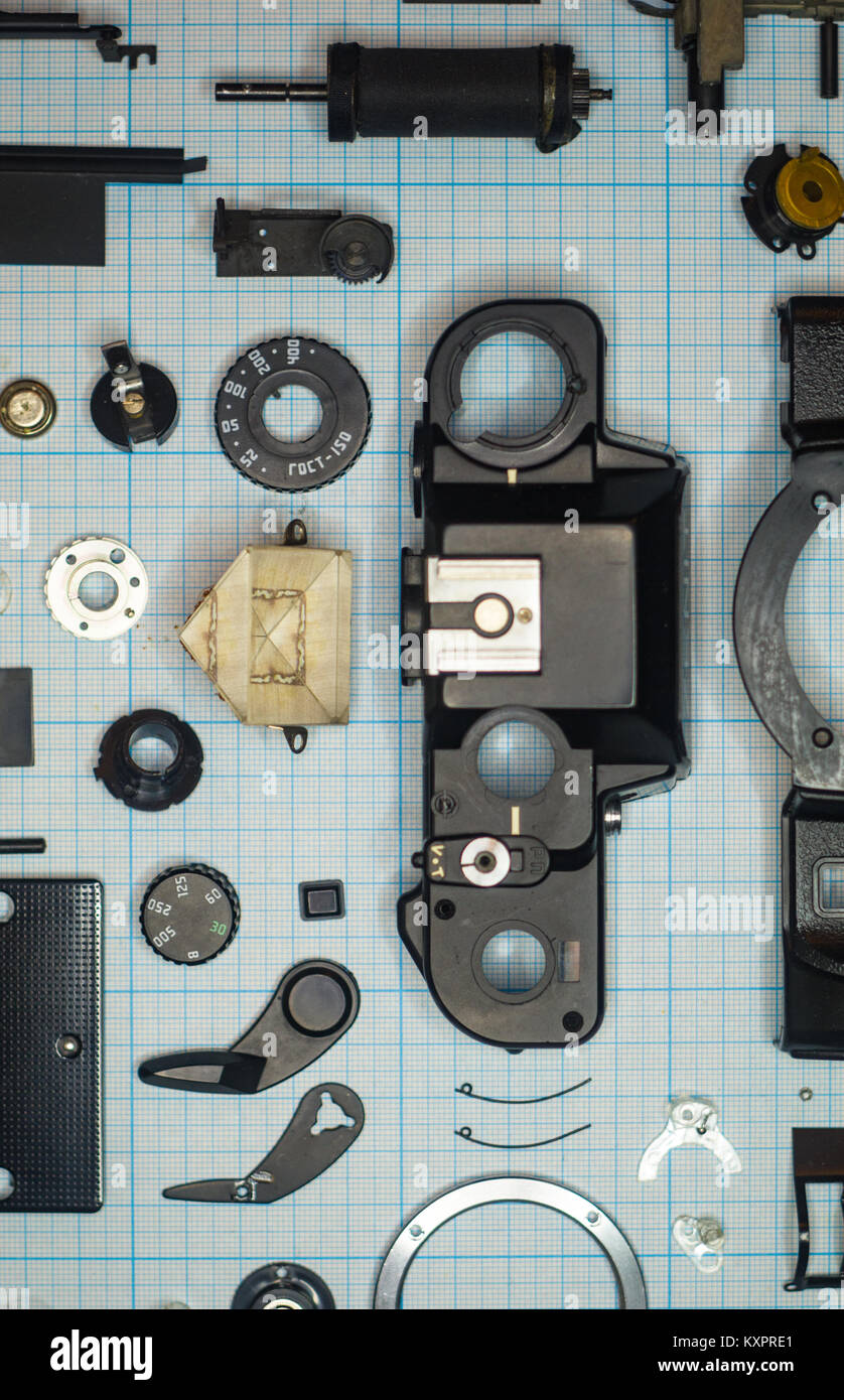 parts are completely disassembled old retro film SLR camera on graph ...