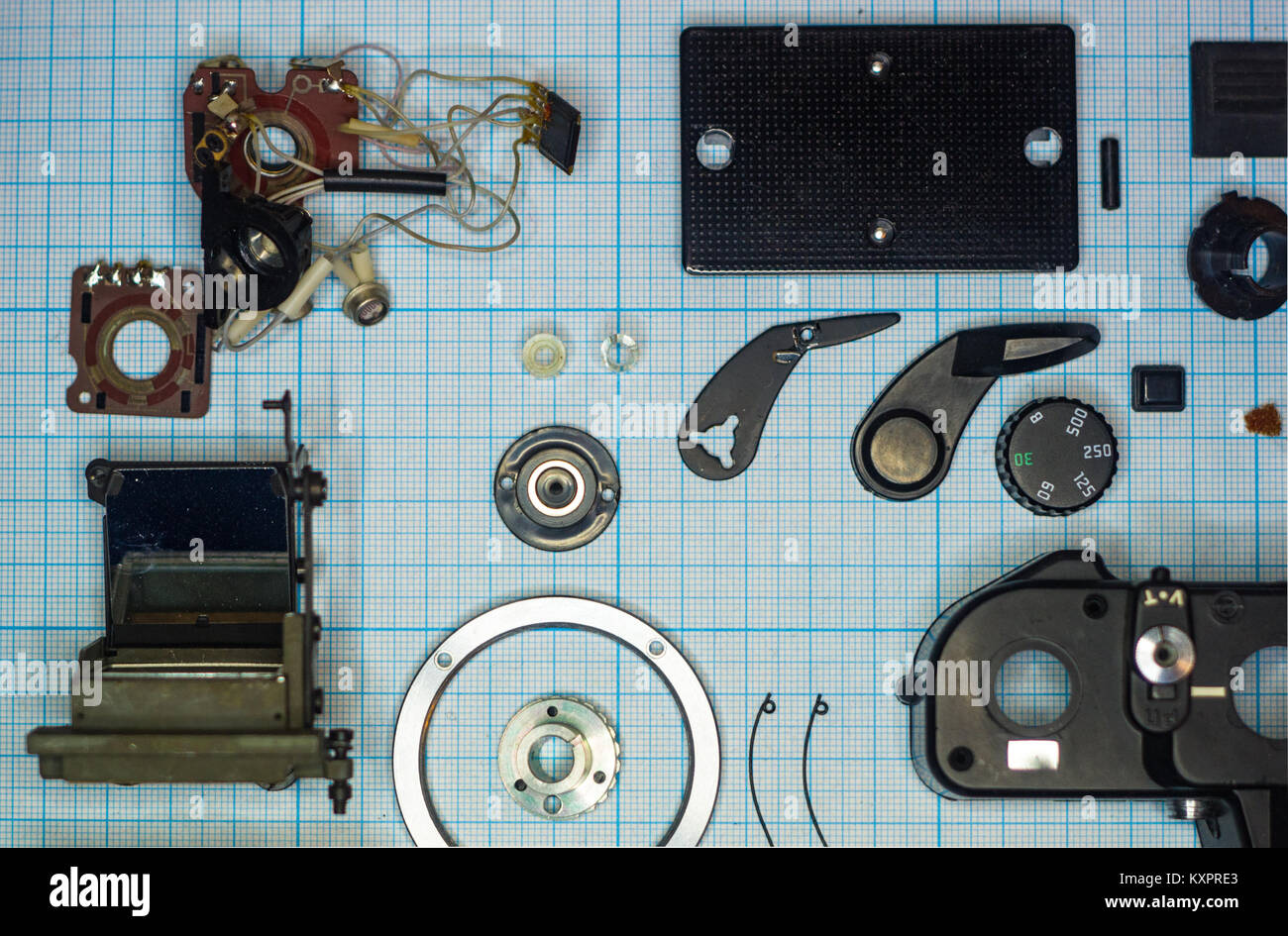 parts are completely disassembled old retro film SLR camera on graph ...