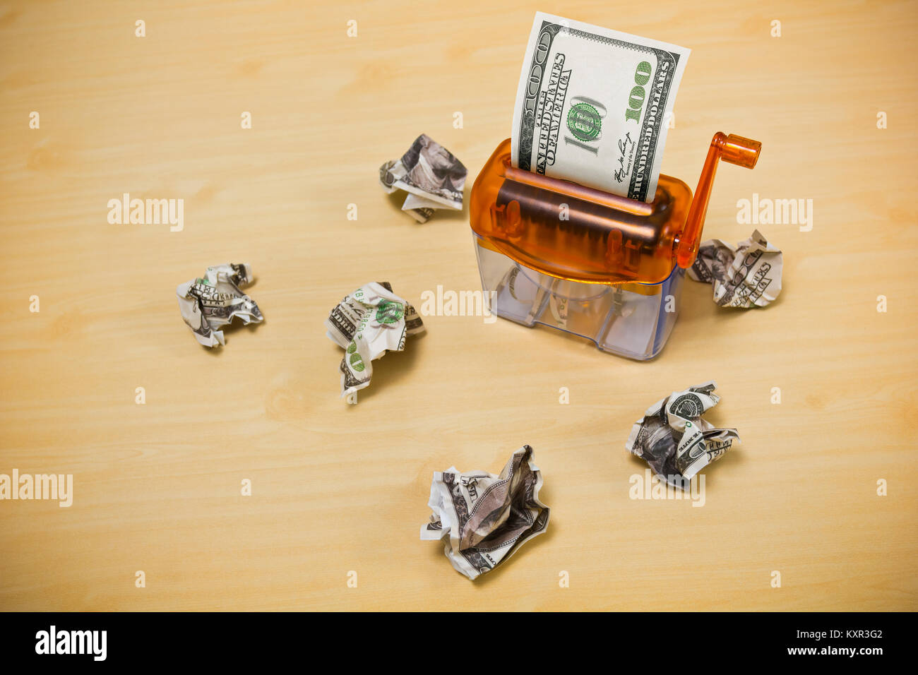 Dollar banknote in a paper shredder portays decreasing value of money ...