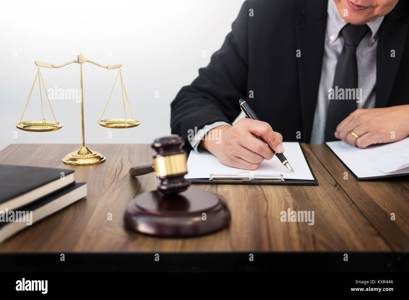 lawyer hand writes the document in court (justice, law) with sounding ...
