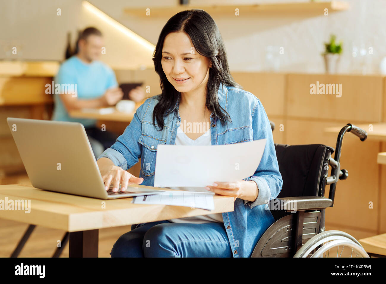 Cheerful handicapped woman holding a sheet of paper Stock Photo - Alamy
