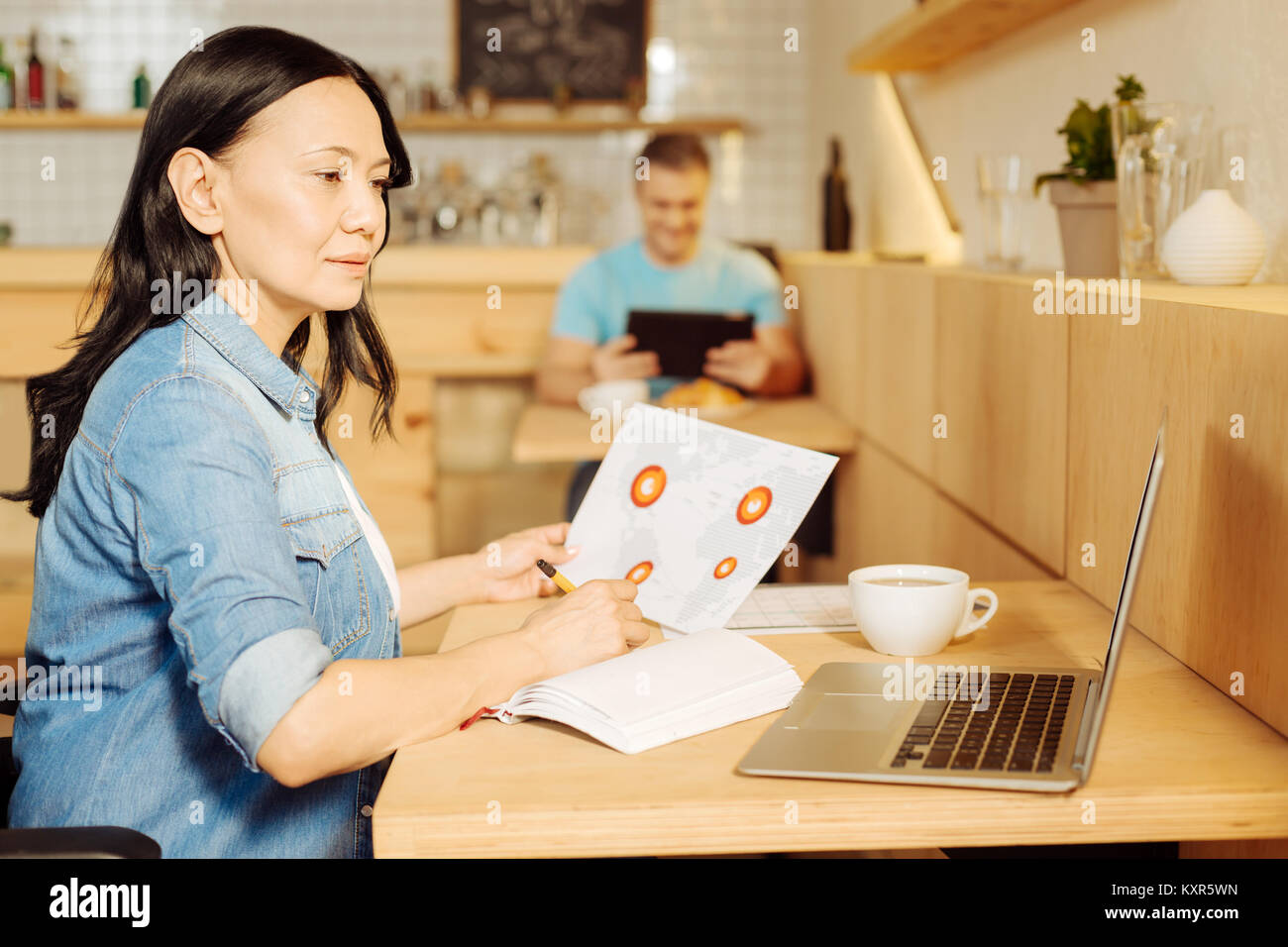 Concentrated disabled woman taking notes Stock Photo - Alamy