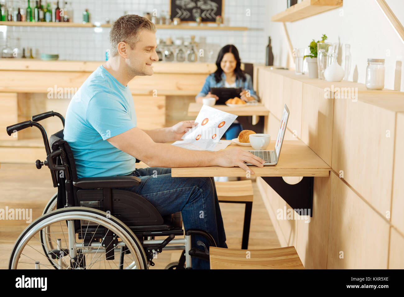 Smiling disabled man working on his laptop Stock Photo - Alamy