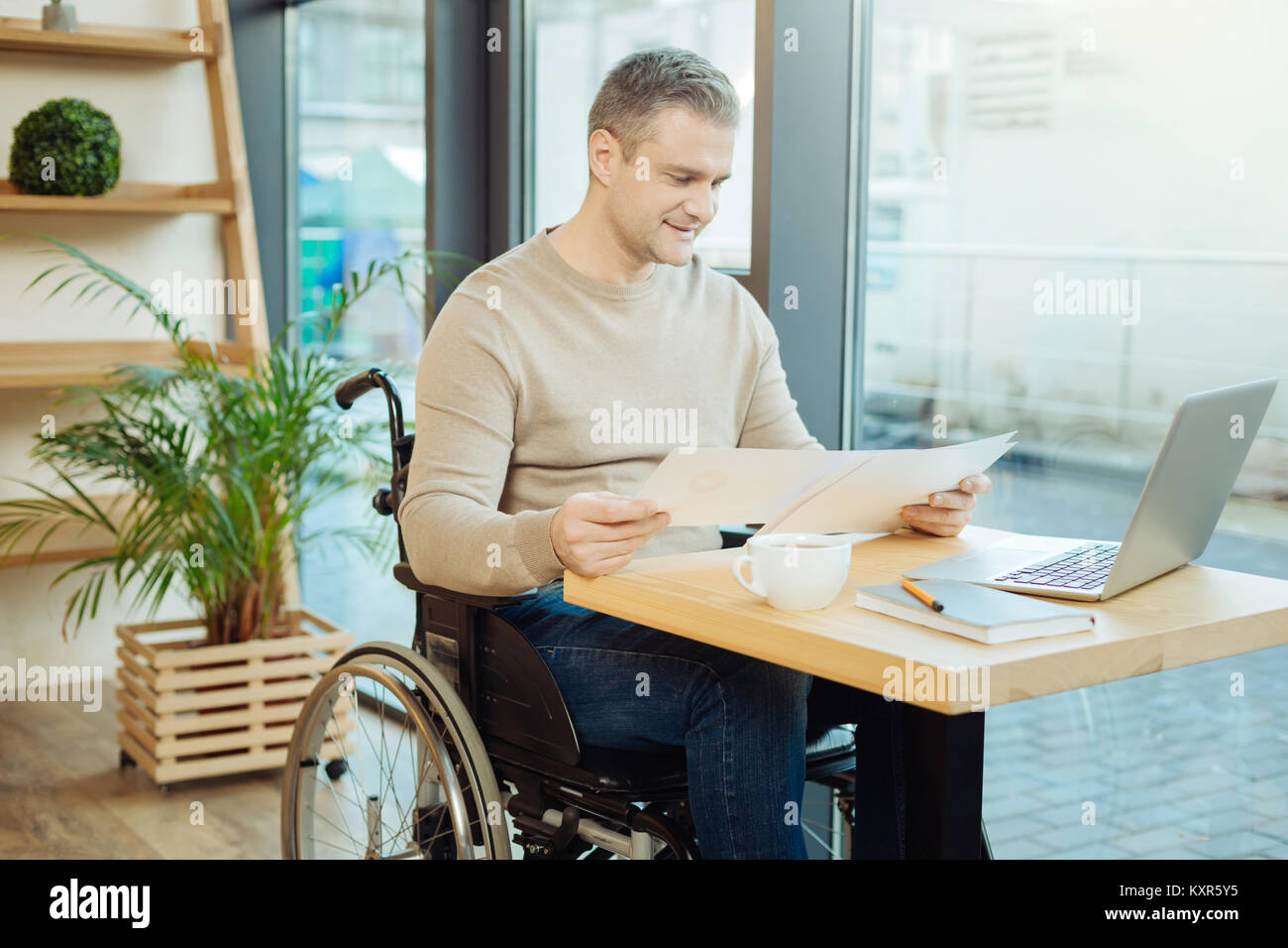 Alert disabled man working in a cafe Stock Photo - Alamy