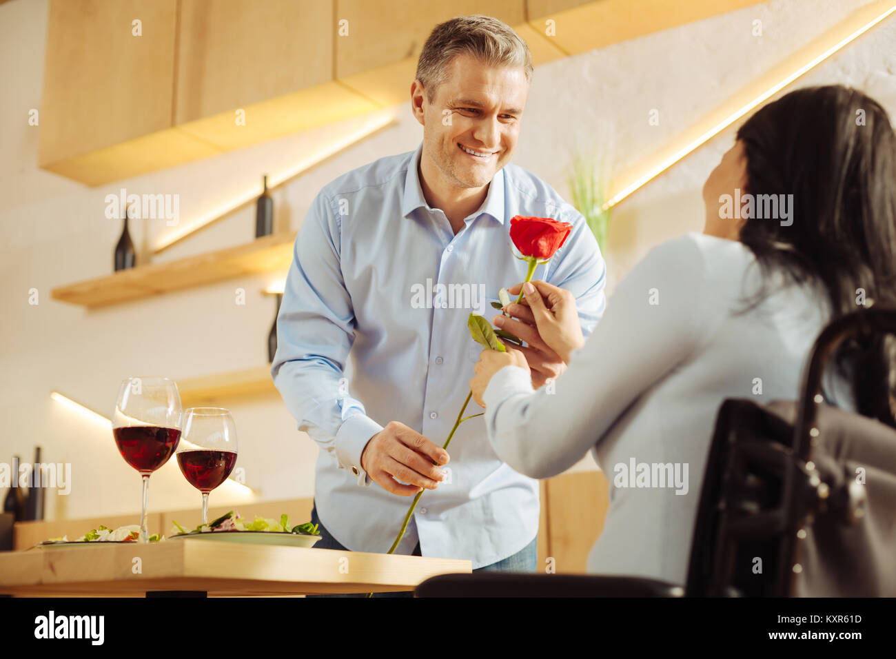 Devoted man giving a rose to his woman Stock Photo - Alamy