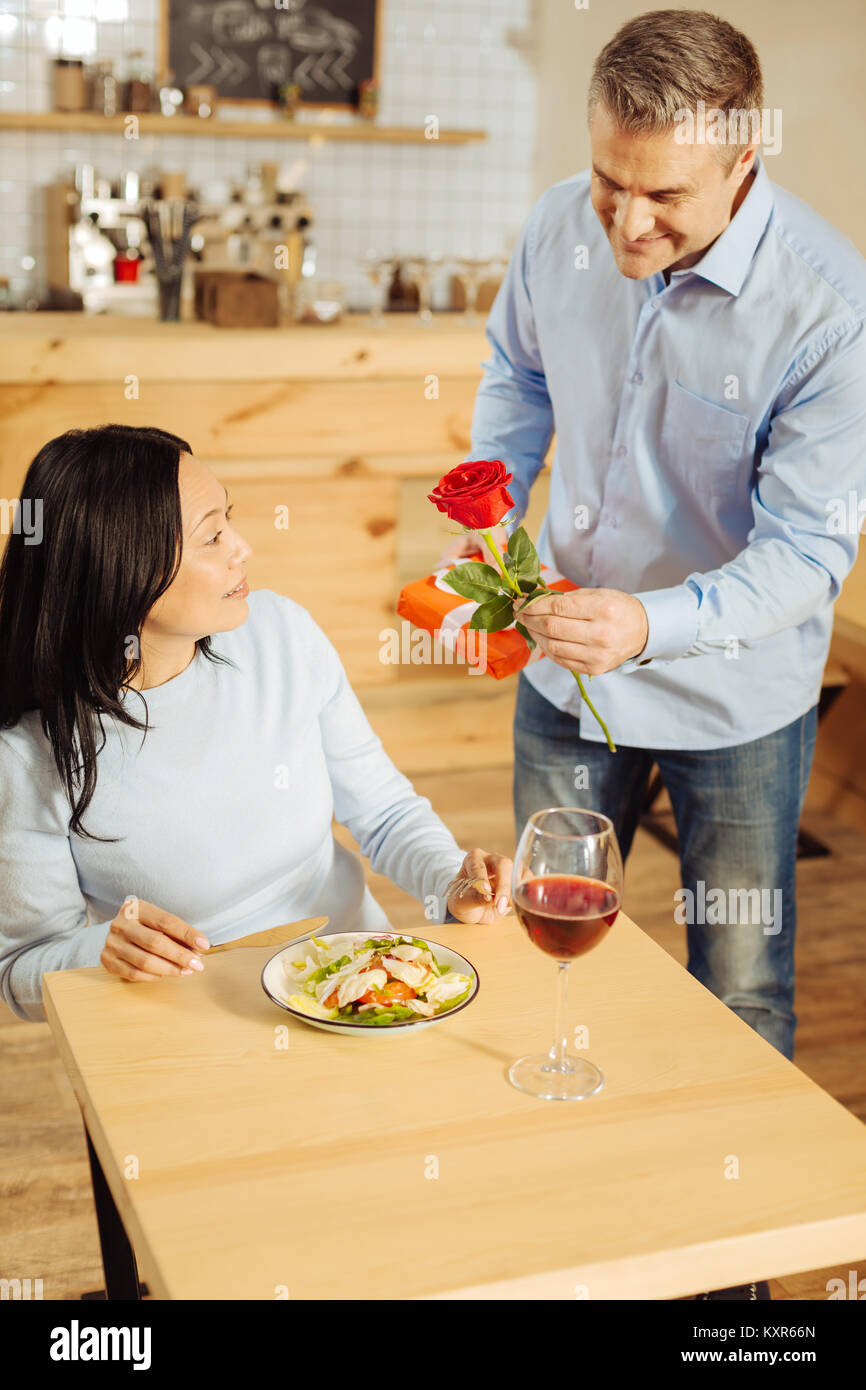 Content man giving rose and present to his woman Stock Photo - Alamy