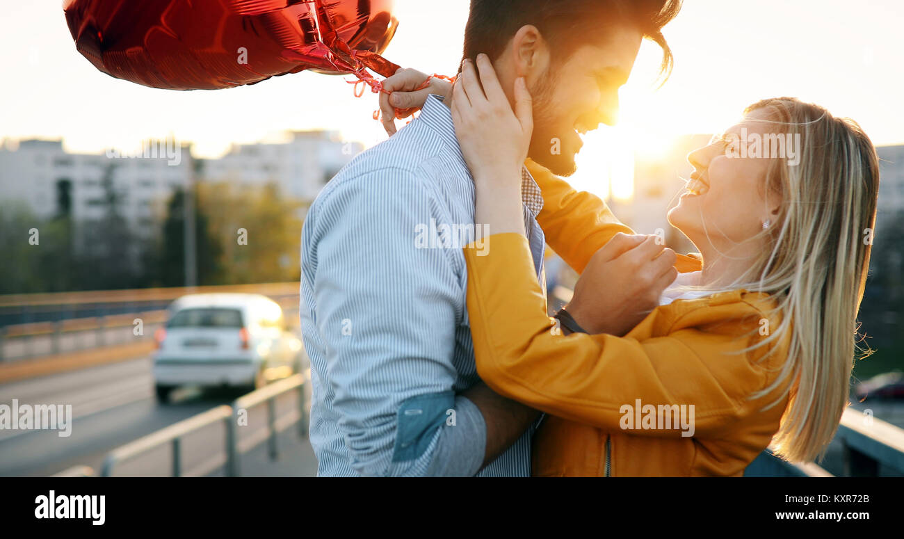 Couple in love cuddling while enjoying beautiful urban sunset together ...