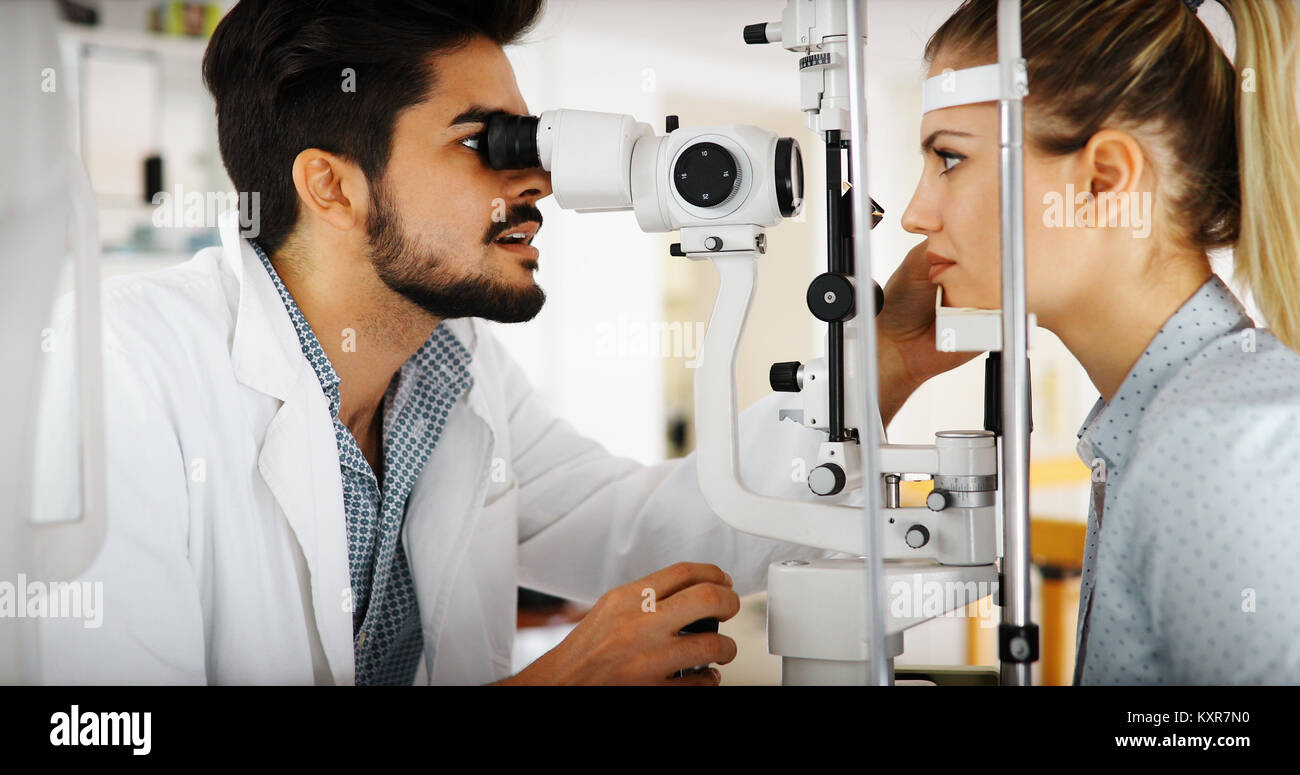 Patient or customer at slit lamp at optometrist or optician Stock Photo ...