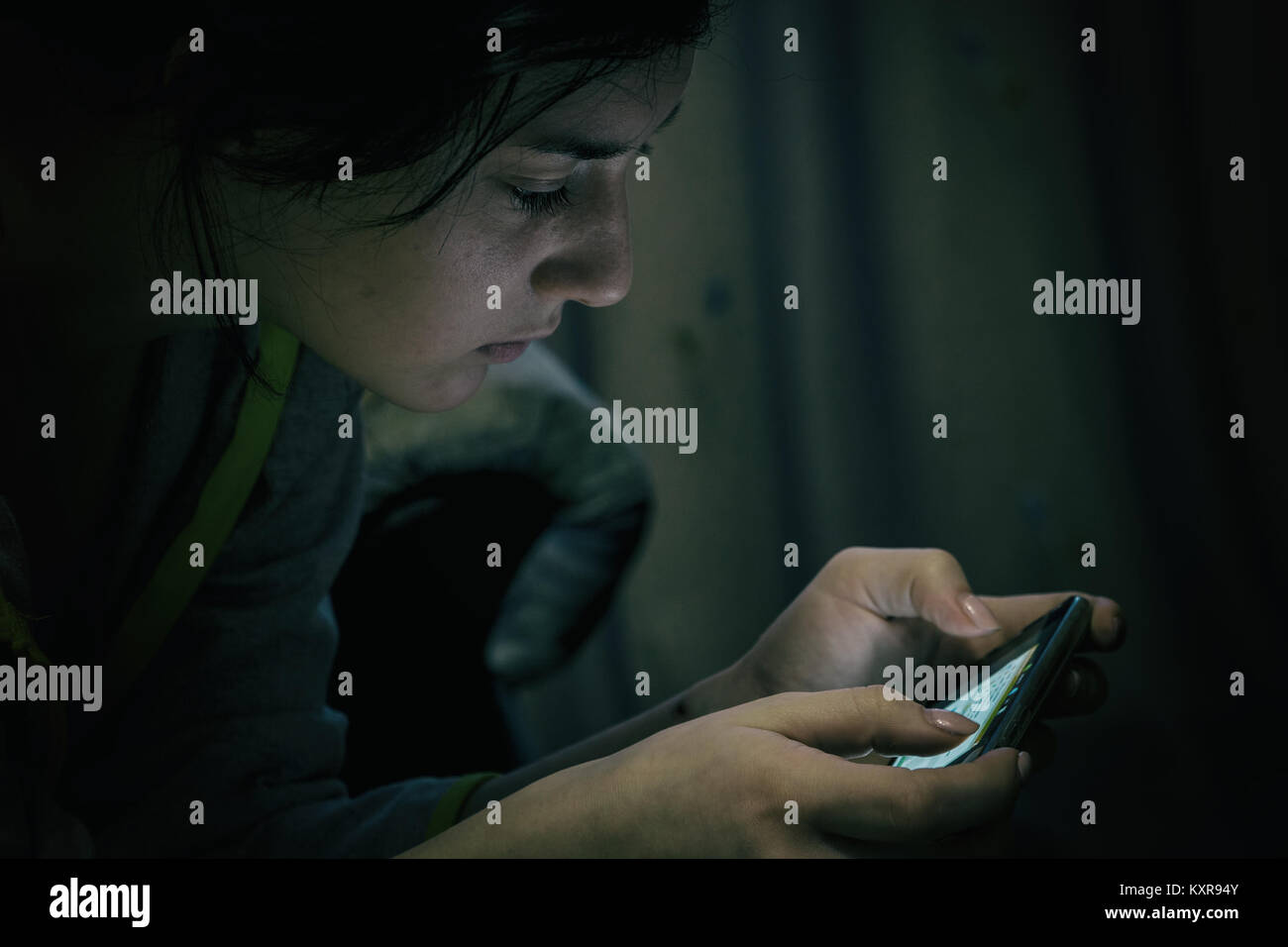 Girl in a dark room with a smartphone Stock Photo - Alamy