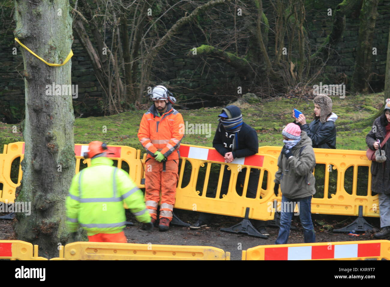 2 masked protesters inside safety barriers around tree due to be felled ...