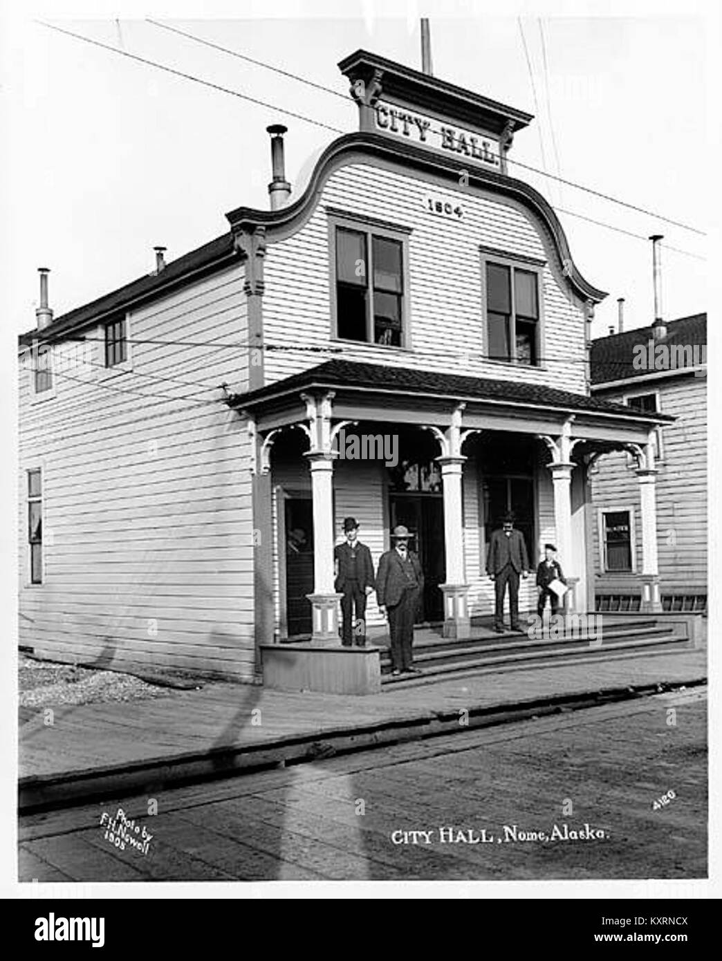 This historical photograph captures the City Hall building in Nome ...