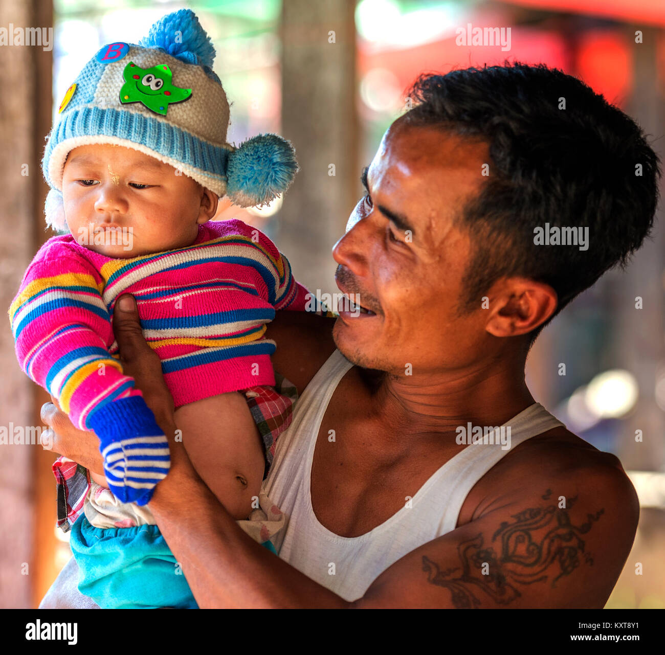 Father looking at his son and holding in his arm, Inle, Myanmar Stock ...