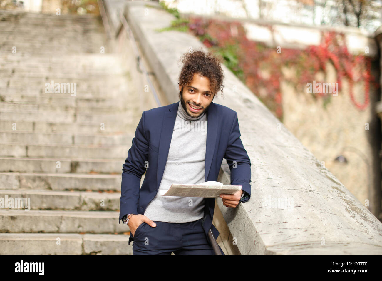 Young male model reading newspaper on open air Stock Photo - Alamy