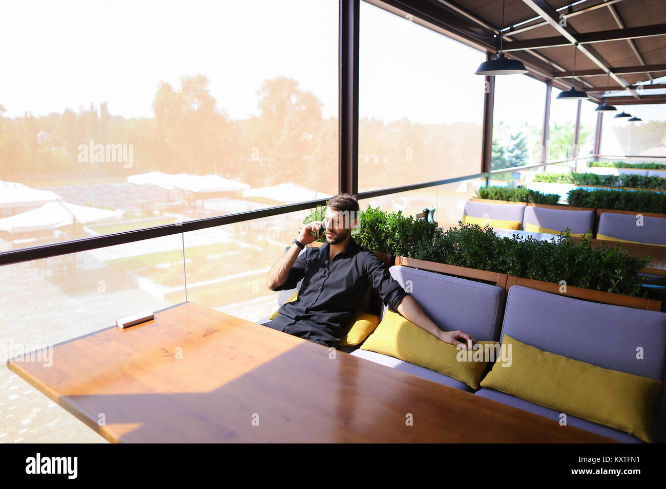 Prosperous man using smartphone for conversation an power bank a Stock ...