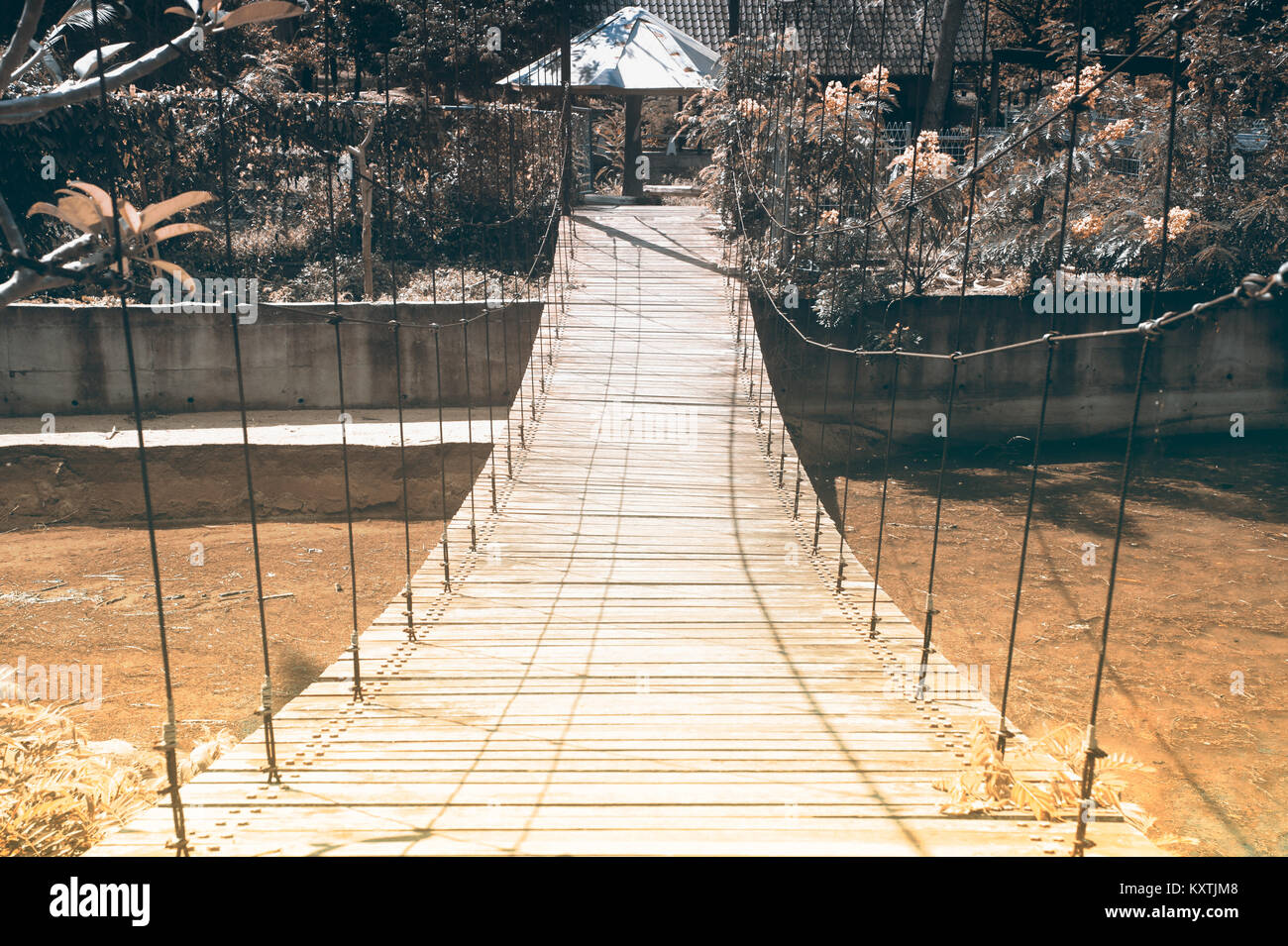 Wire hanging bridge with wooden pathway in Thailand Stock Photo - Alamy