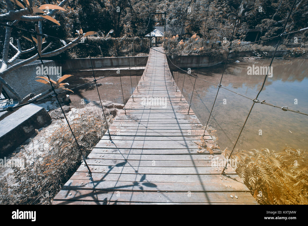 Wire hanging bridge with wooden pathway in Thailand Stock Photo - Alamy