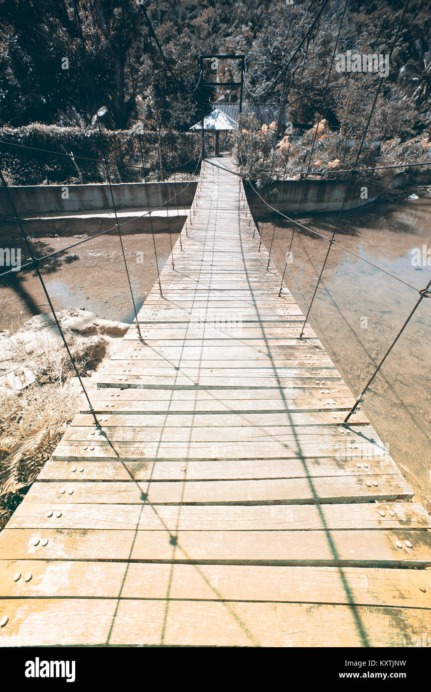 Wire hanging bridge with wooden pathway in Thailand Stock Photo - Alamy
