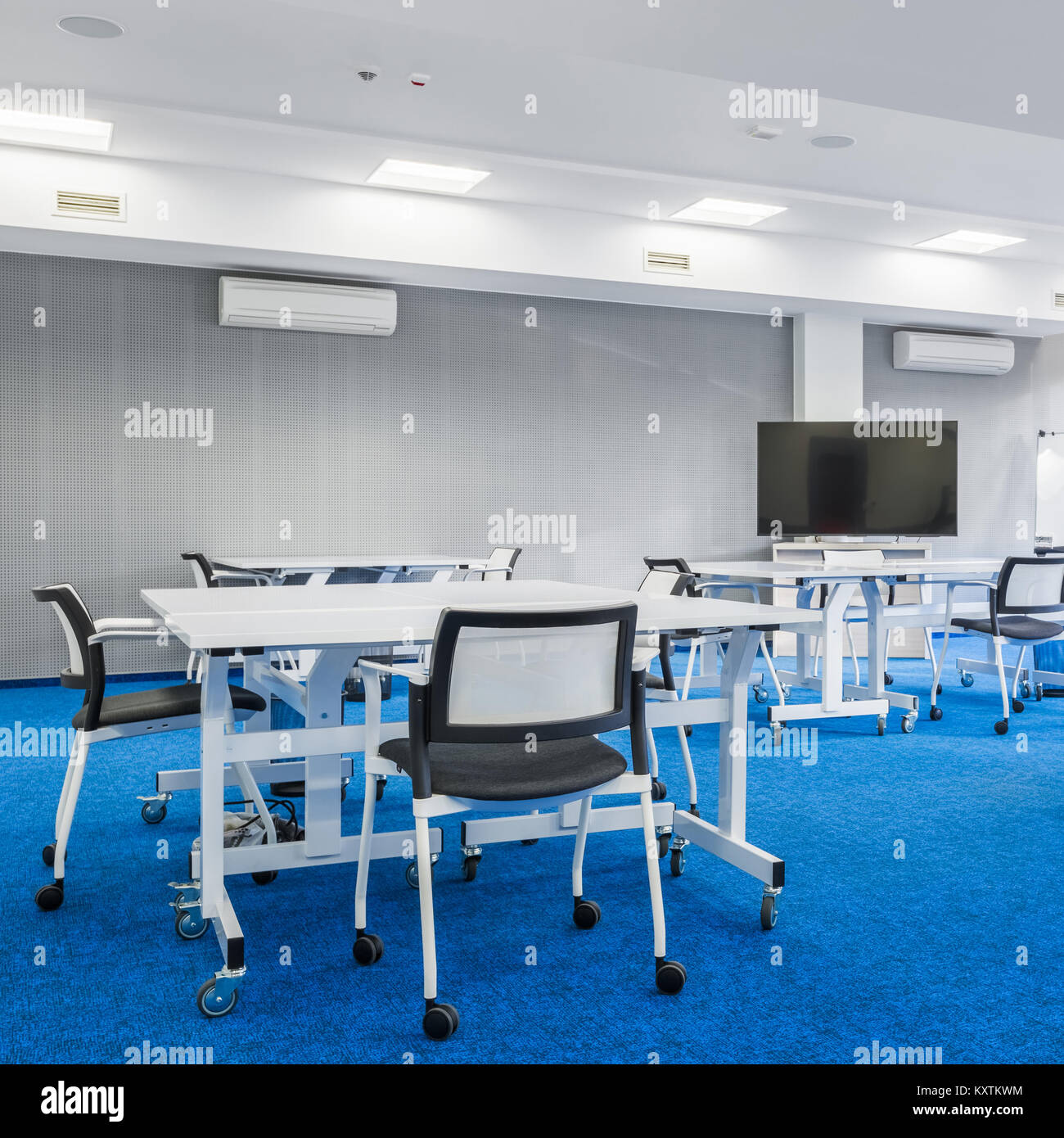 Modern group study room in white and blue with desks, chairs and big ...