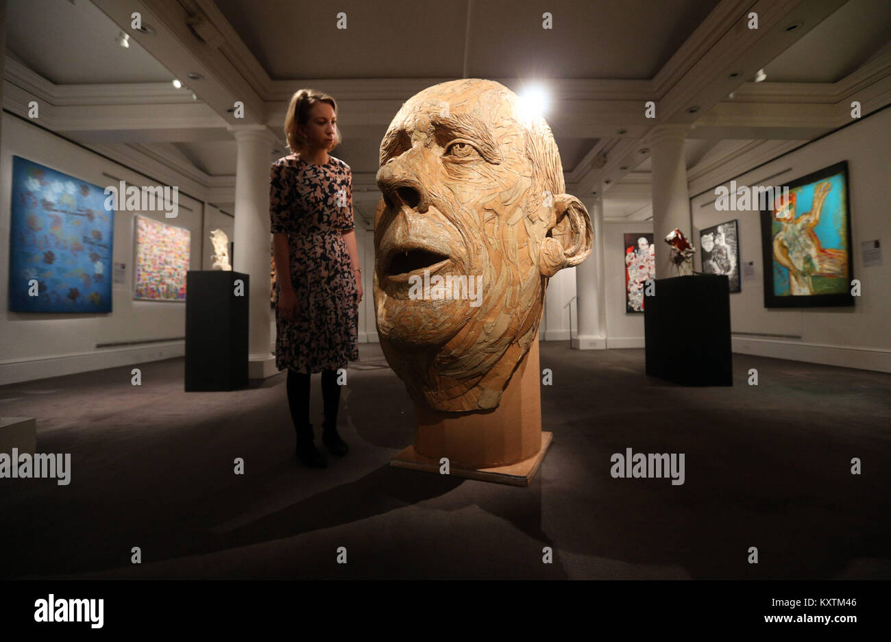 A gallery employee looks at Cardboard Portrait of David Rushbrook by ...