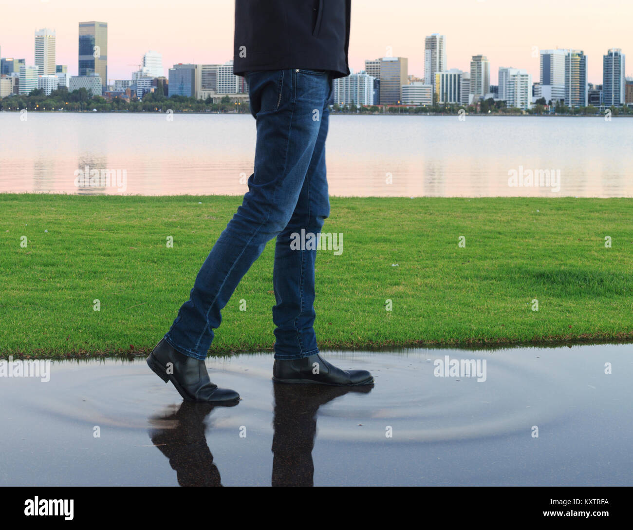 A man wearing boots walking through a puddle Stock Photo - Alamy