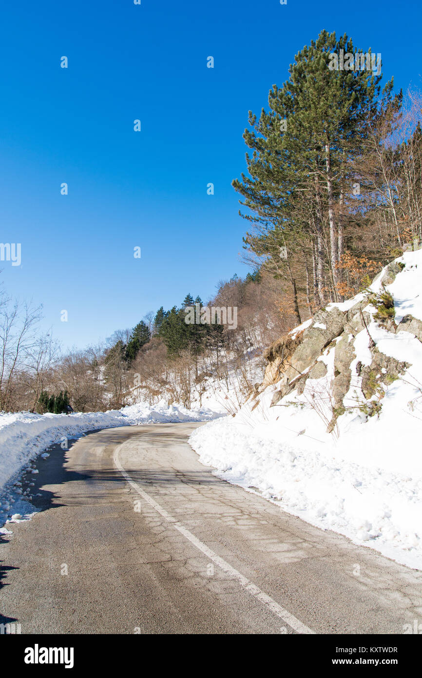 Road cleaned from snow on the mountain with blue sky Stock Photo - Alamy