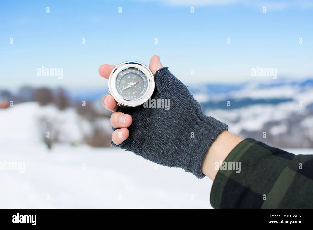 Man holding a metal compass on snowy mountain Stock Photo - Alamy
