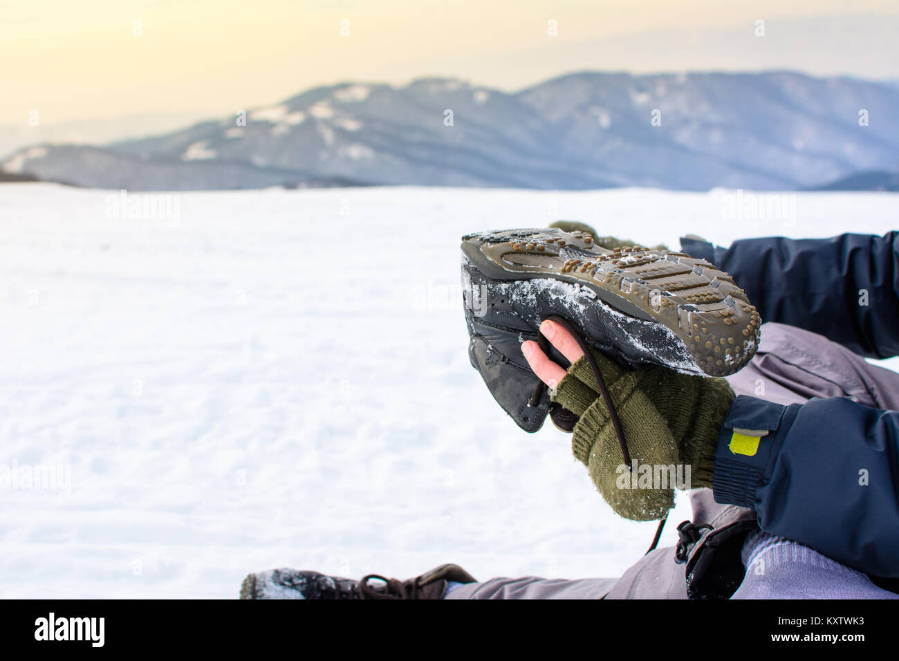 Man removing snow from his shoe on a winter hiking trip Stock Photo - Alamy