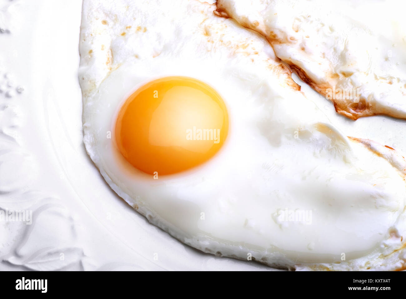 One egg baked and dressed on white plate in close-up Stock Photo - Alamy