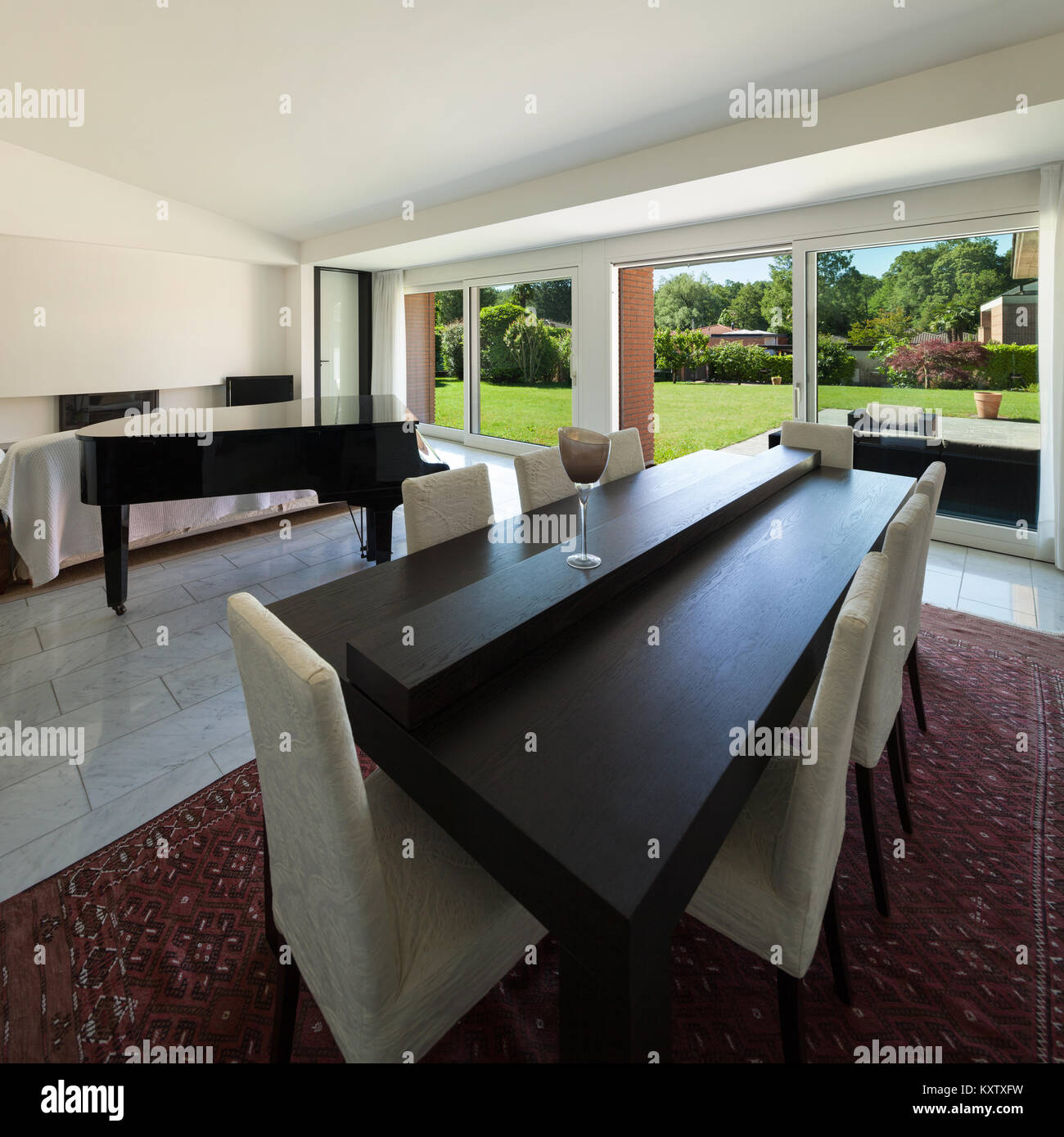 Dining room with piano of a modern house, interior Stock Photo - Alamy