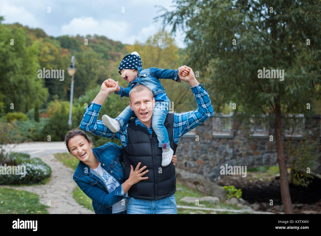 Young family walking in the park. They hug and laugh Stock Photo - Alamy