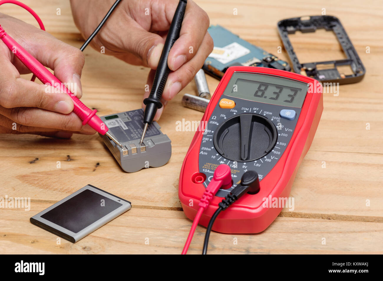 electrician using the digital multimeter to check the battery Stock ...
