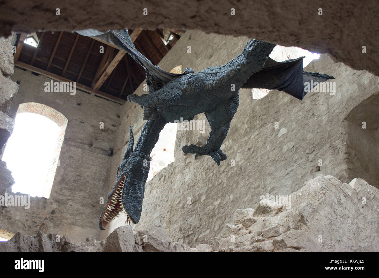 Dragon flying into the castle. Stone and brick walls and three windows ...