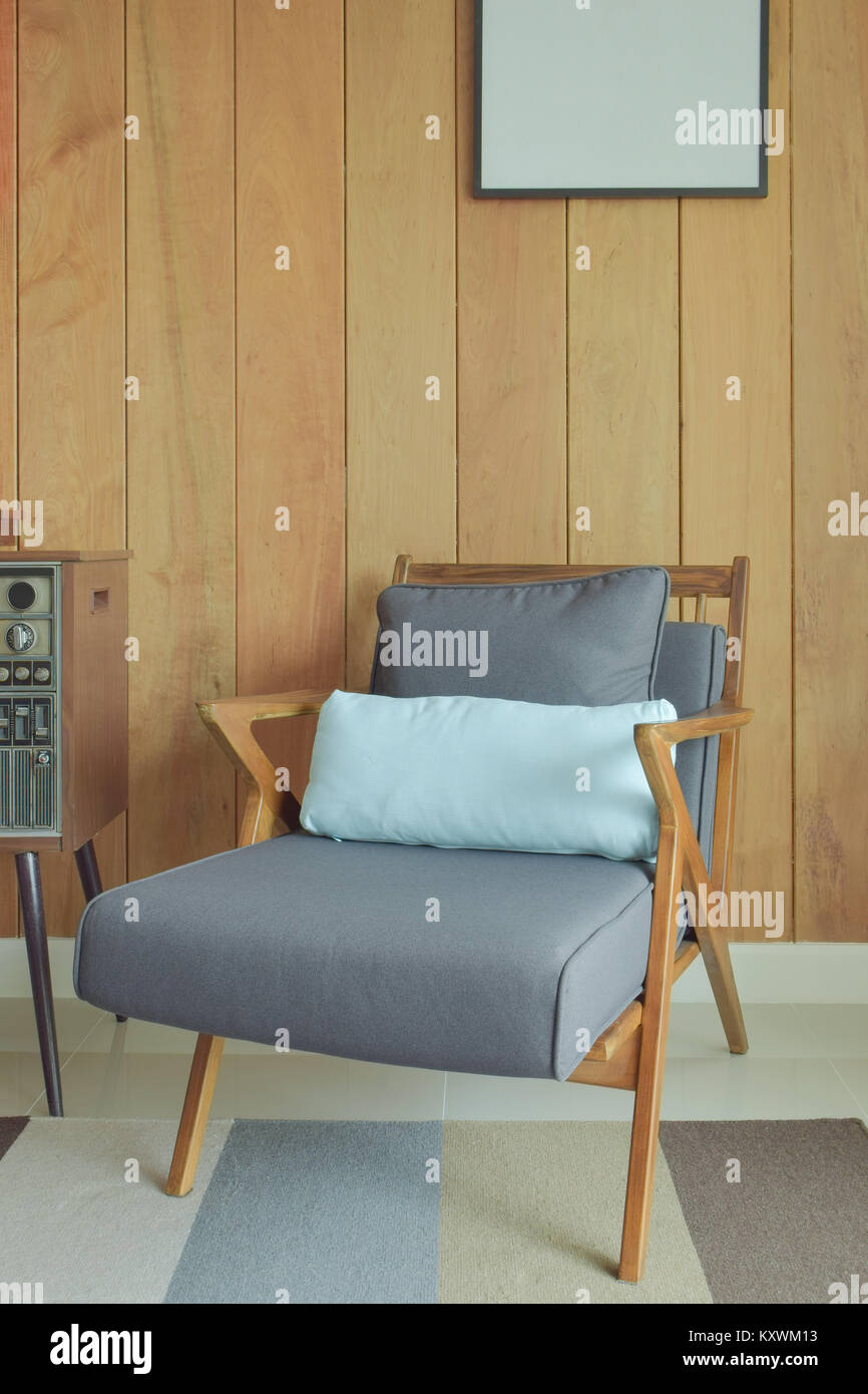 Easy lounge chair with wooden wall background in retro style decoration ...