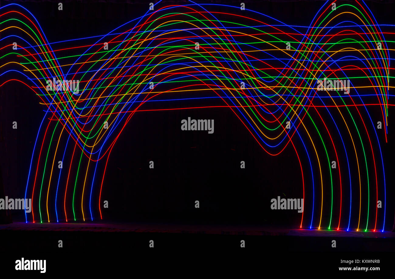 multi-coloured light trails patterns in the shape of waves and an arch ...