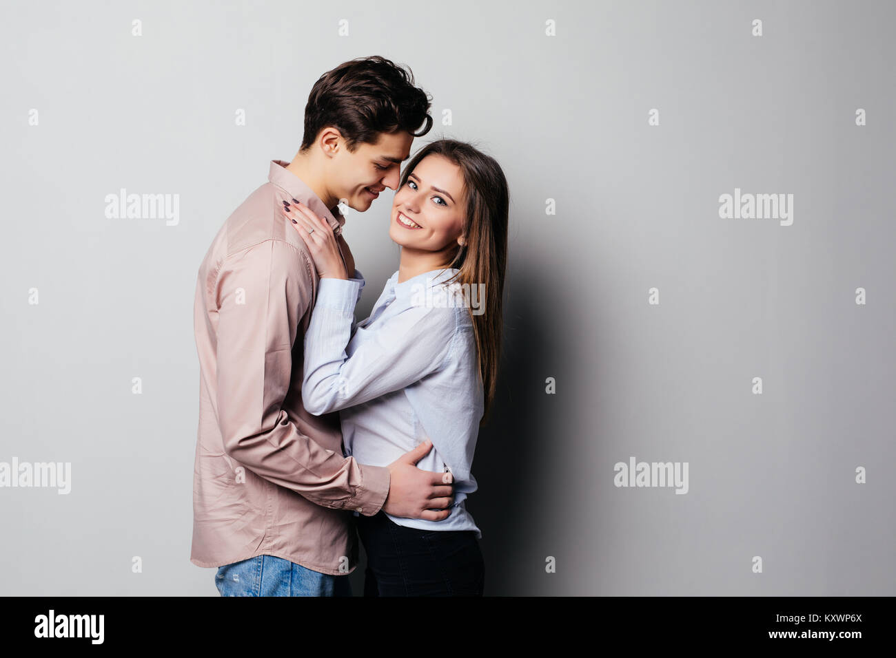 Vertical photo of two young cheerful people hugging each other against ...