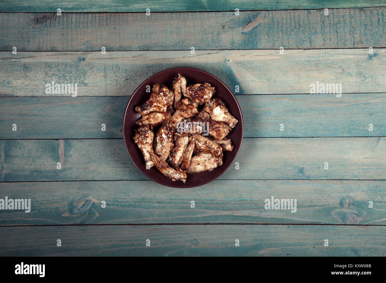 Fried chicken wings in clay plate on wooden table Stock Photo - Alamy