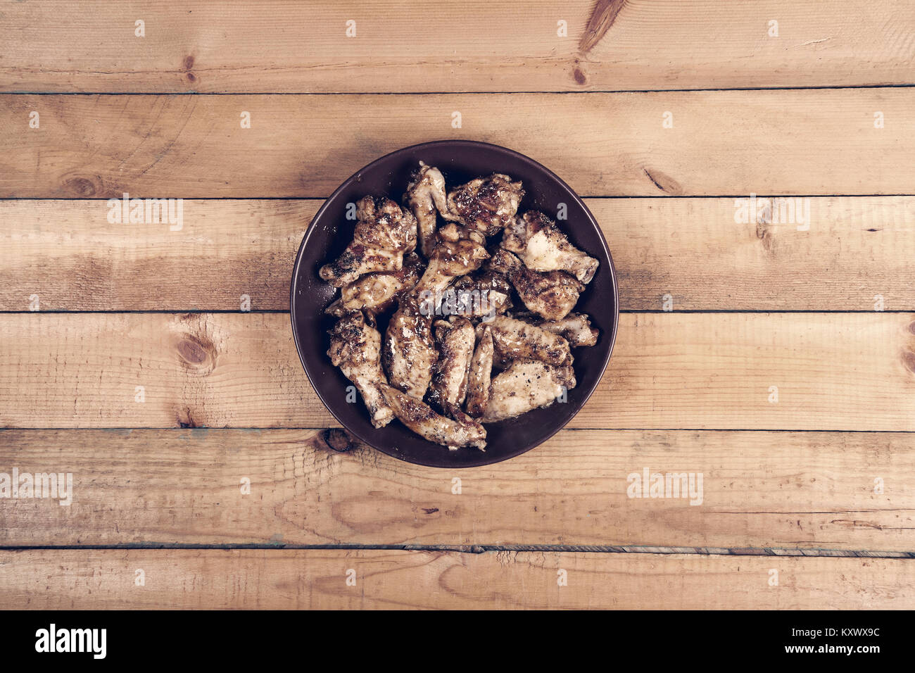Fried chicken wings in clay plate on wooden table Stock Photo - Alamy