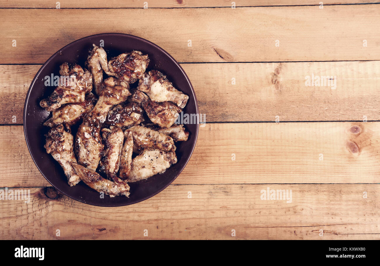 Fried chicken wings in clay plate on wooden table Stock Photo - Alamy
