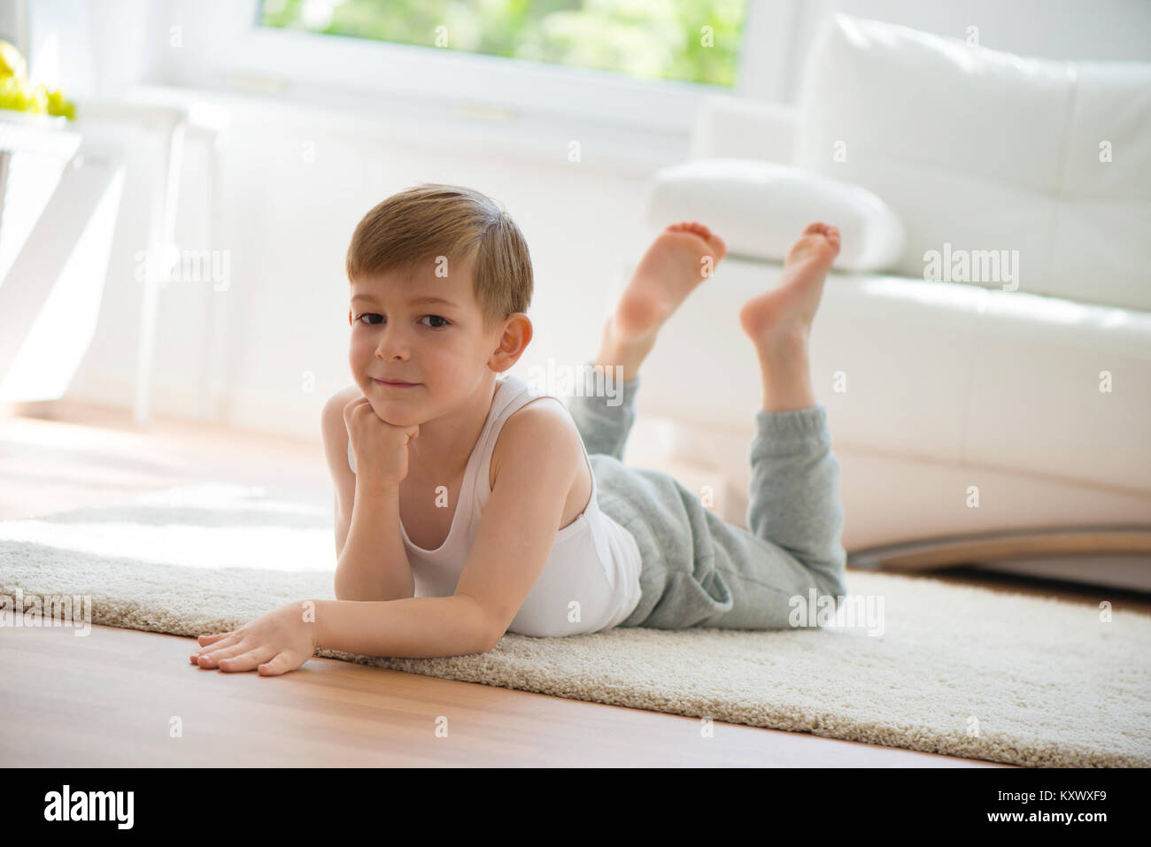 Cute little boy lying on floor at home Stock Photo - Alamy