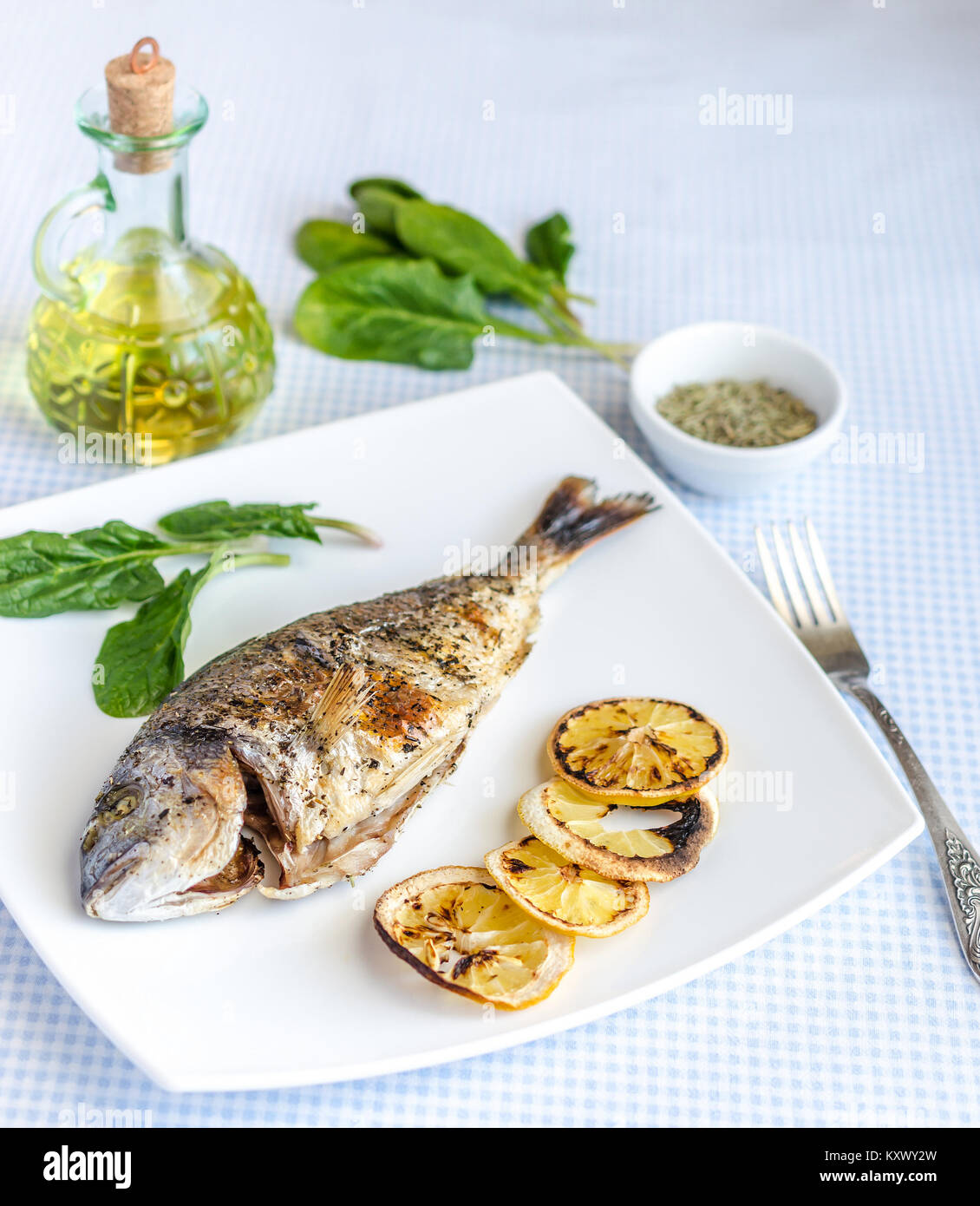Grilled dorada fish with lemon and spinach Stock Photo - Alamy
