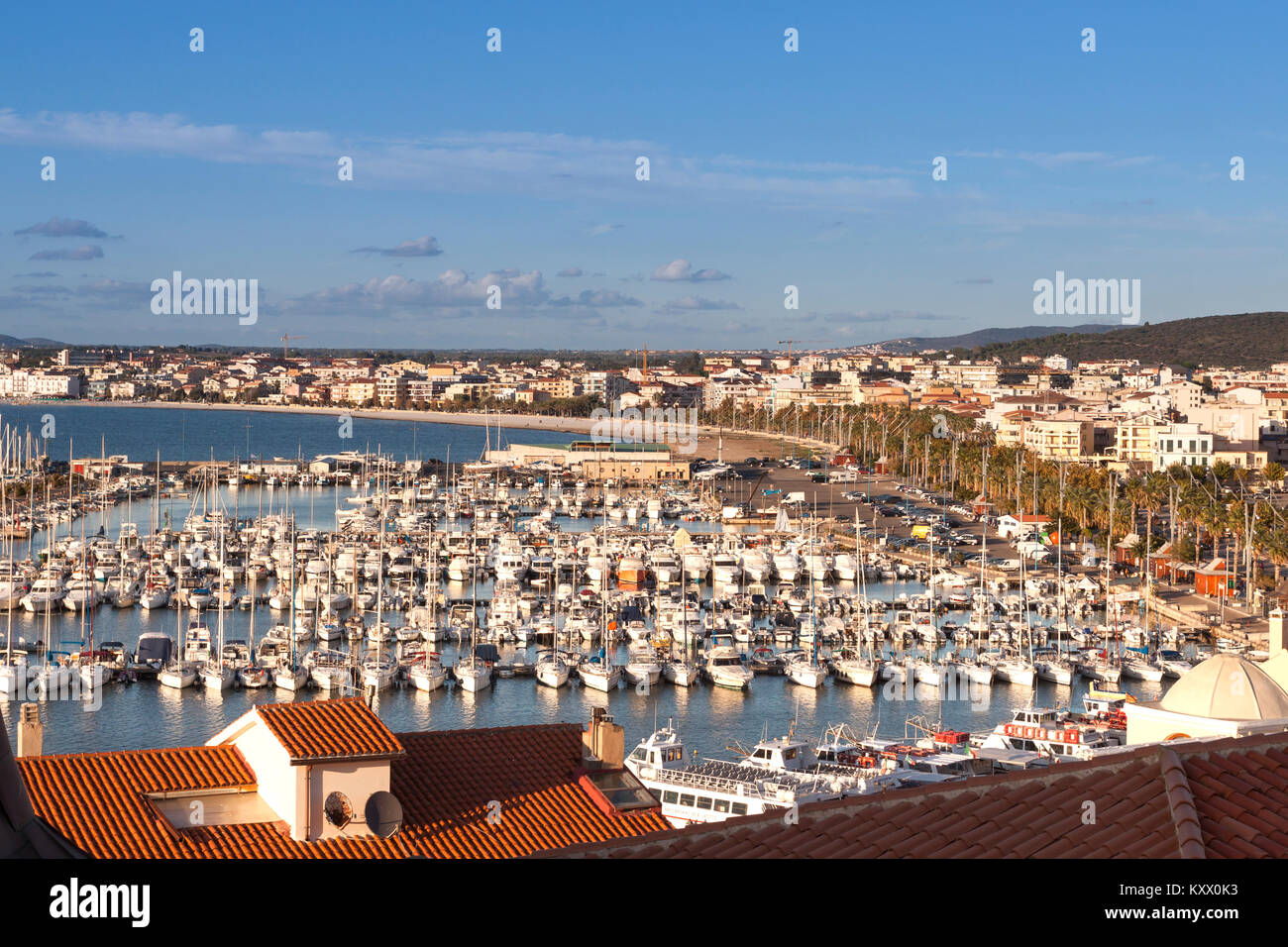 Aerial view of city against romantic skyline at sunset. Alghero ...