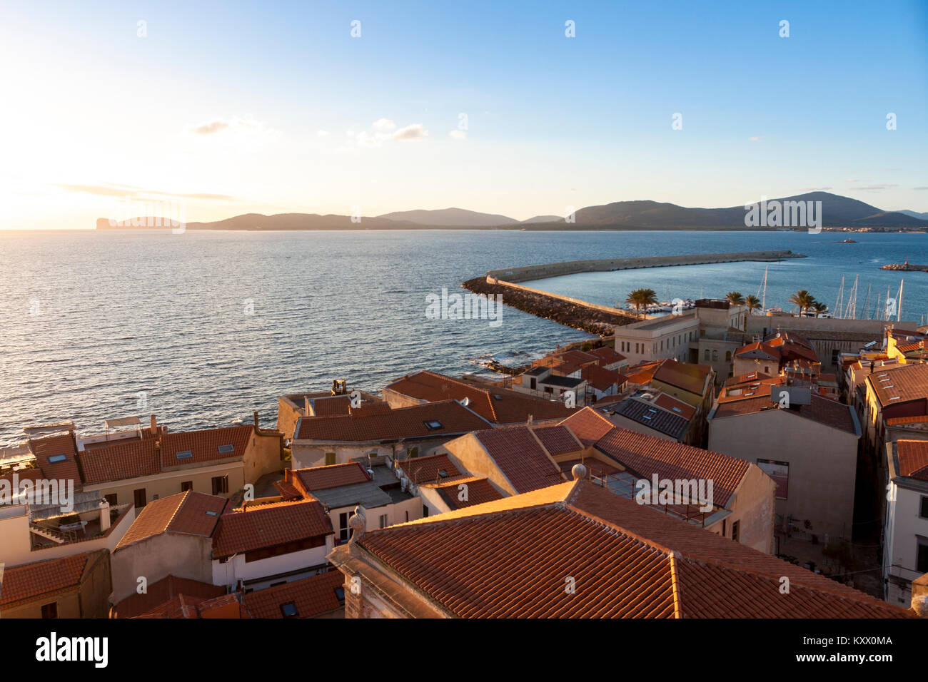 Aerial view of city against romantic skyline at sunset. Alghero ...