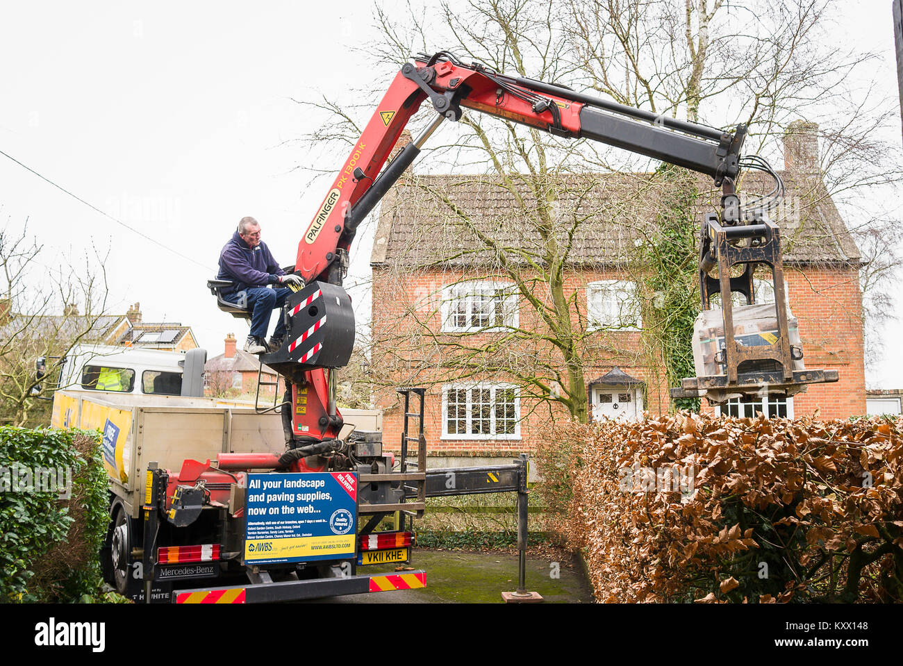 A Builders merchant truck delivering a load of paving slabs to an ...