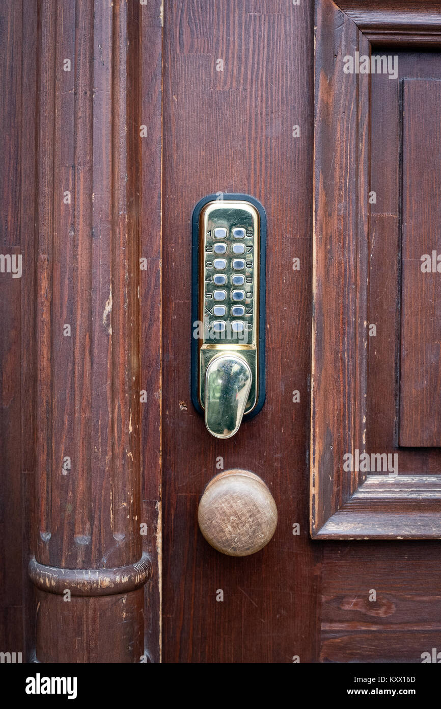gold color code key on brown wooden door Stock Photo - Alamy