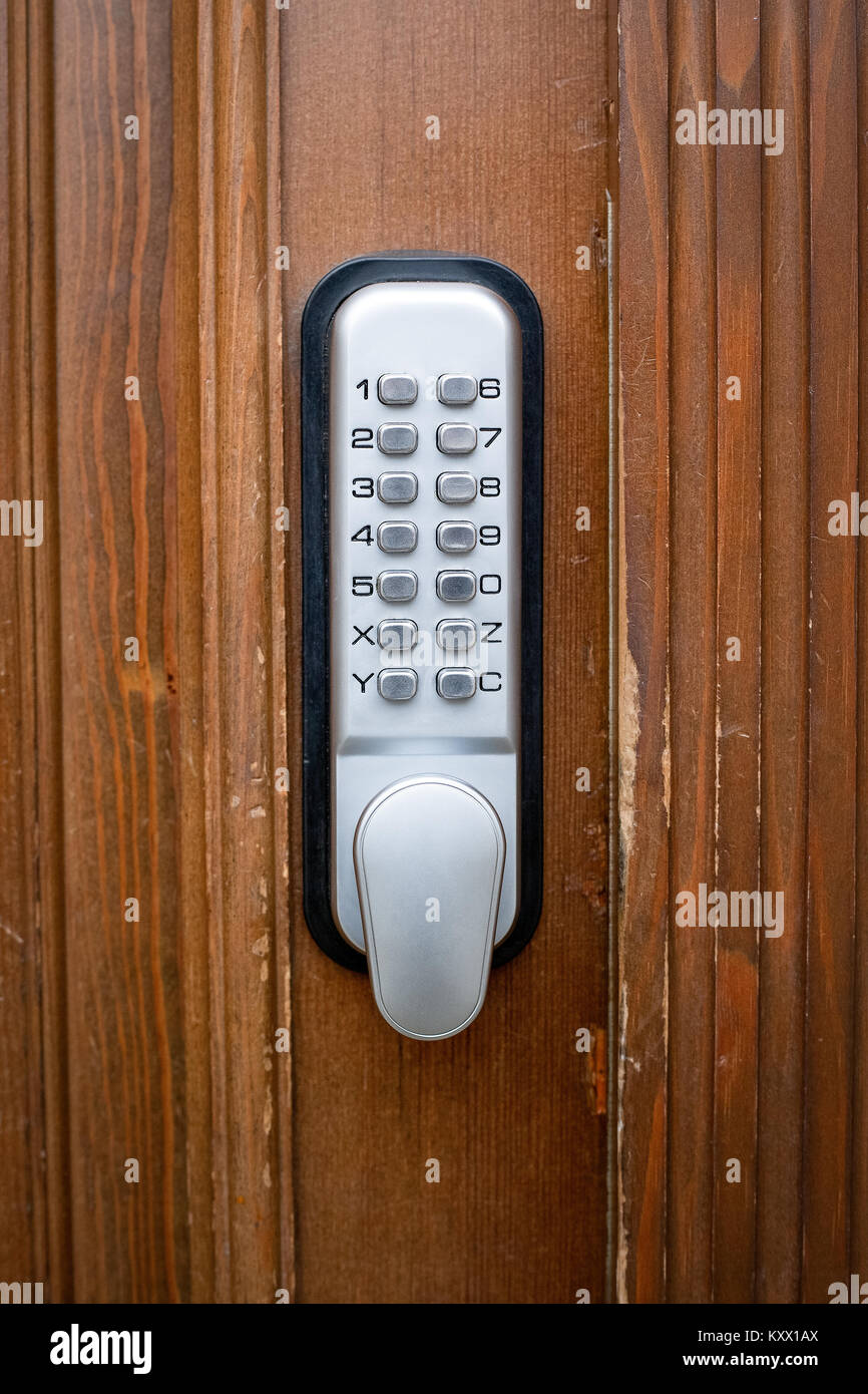 Silver color code key on brown wooden door Stock Photo - Alamy