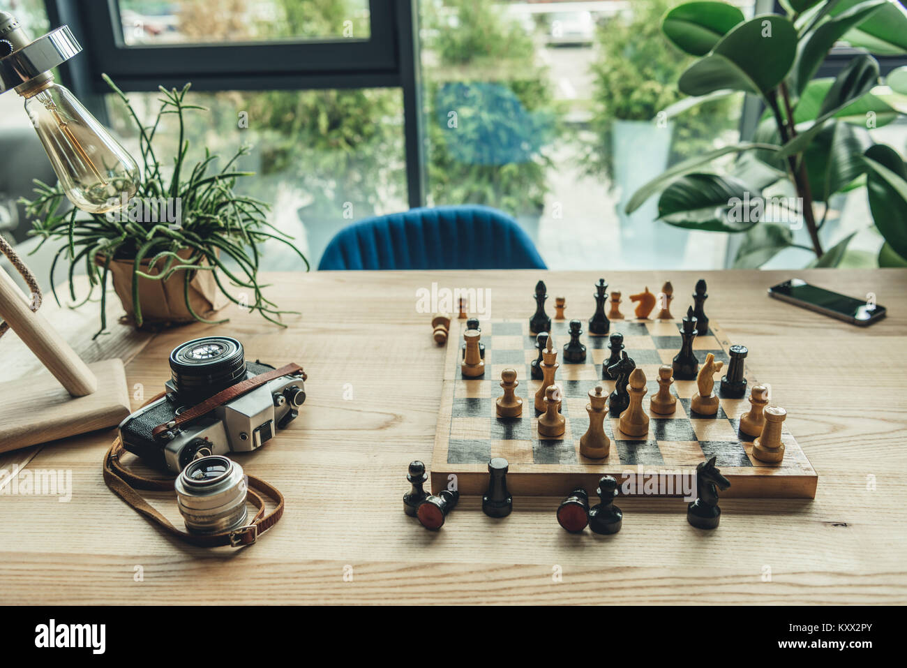 Creative workplace concept with old retro camera, chess board and chess ...