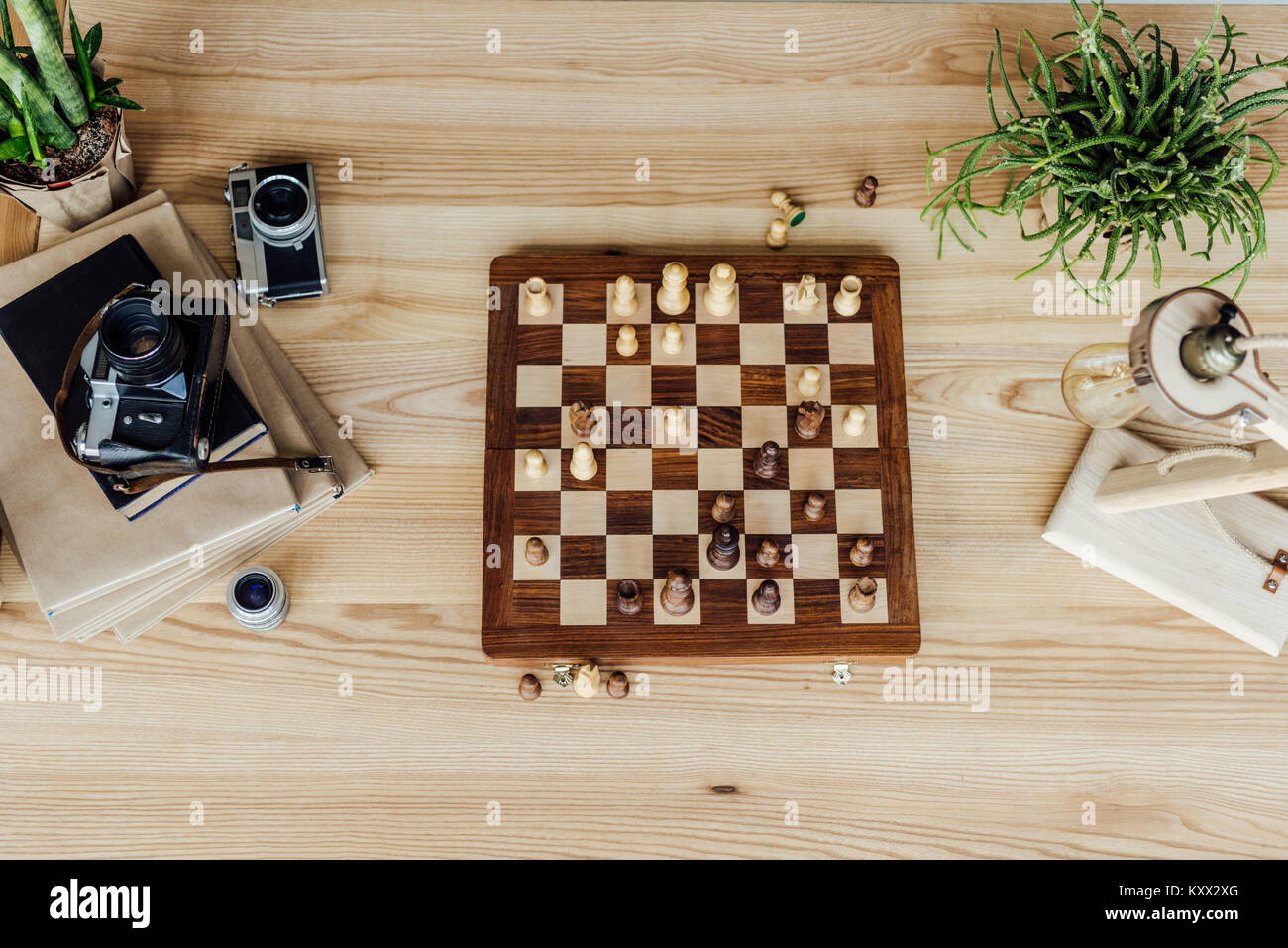 Above view of chess board set with old vintage cameras and books on ...