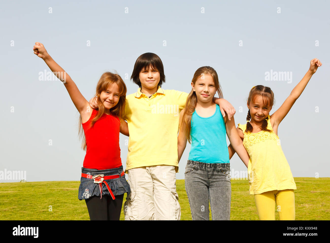 Group of four happy children showing unity Stock Photo - Alamy