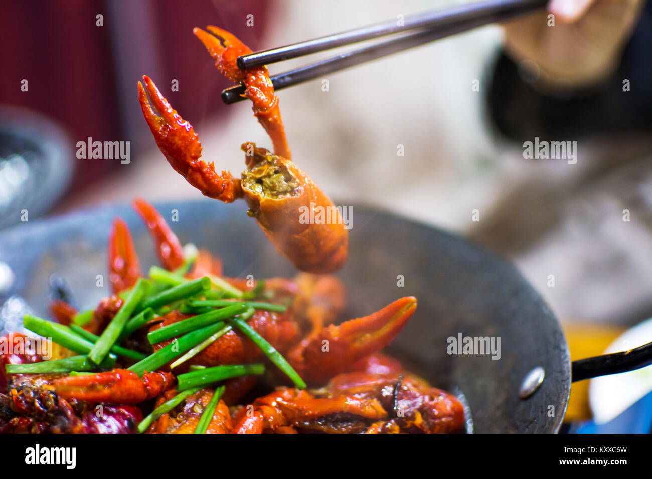 Chopsticks taking crayfish from spicy crayfish pot on the table Stock ...